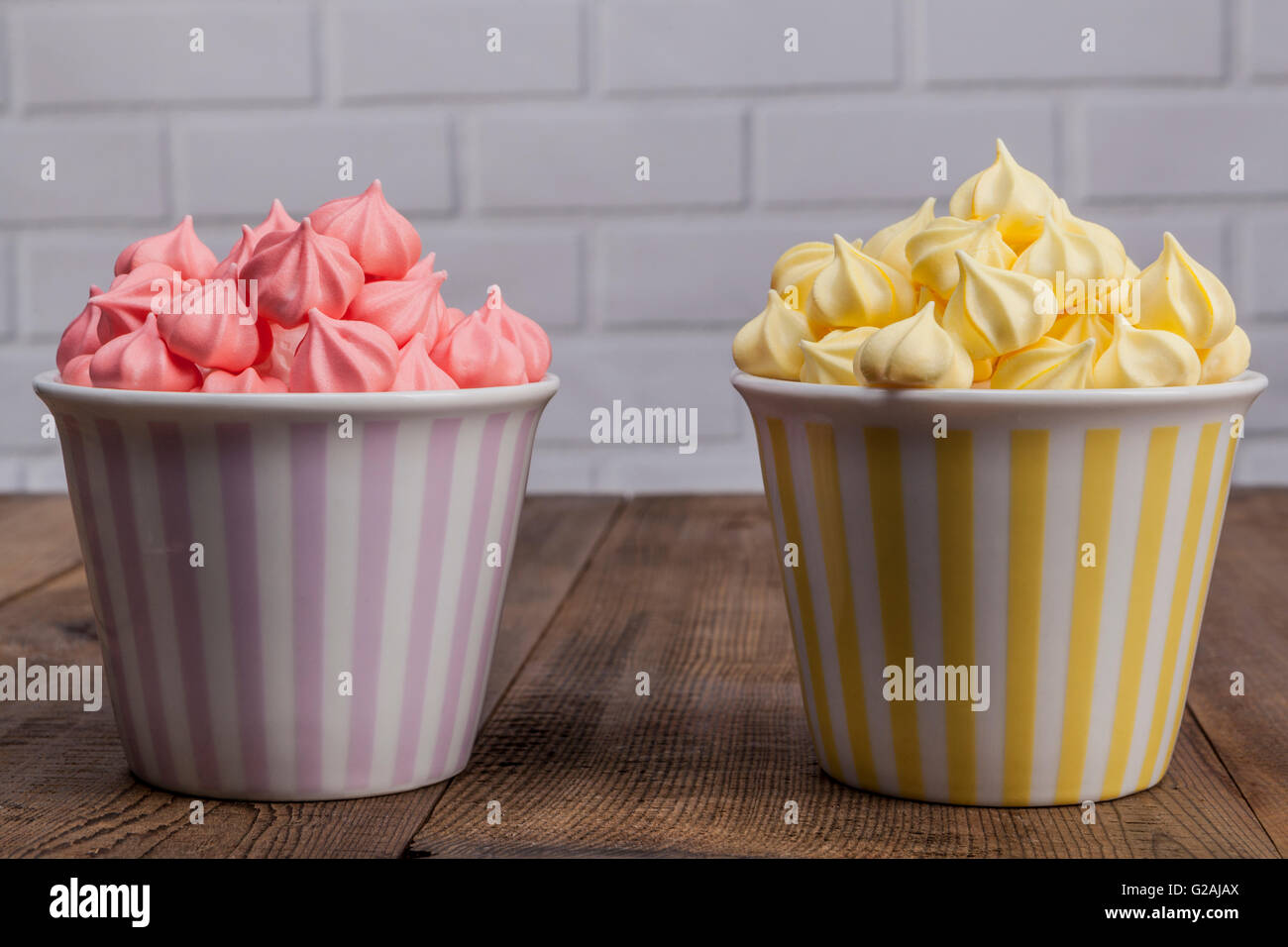 Pink and yellow sweets on wood table Stock Photo - Alamy