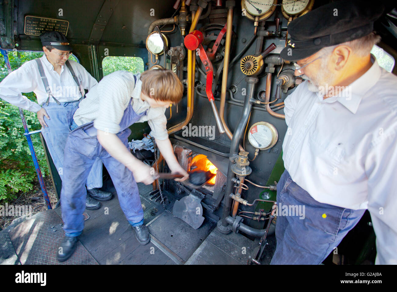A trainee fireman adding coal to the firebox at the Didcot Railway ...