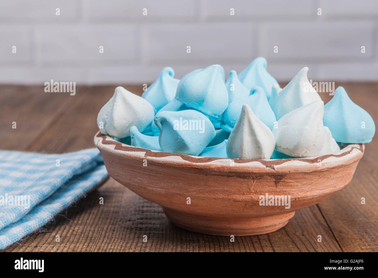 Blue sweets on wood table and white brick background Stock Photo - Alamy