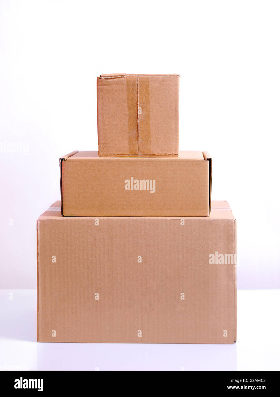 Three brown cardboard boxes aligned isolated over white table Stock ...