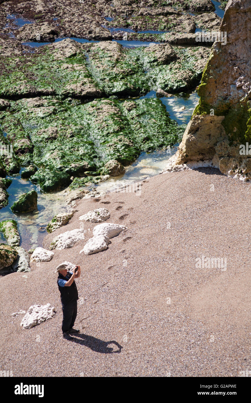 Looking down at man and shadow taking a photo on beach at Freshwater ...