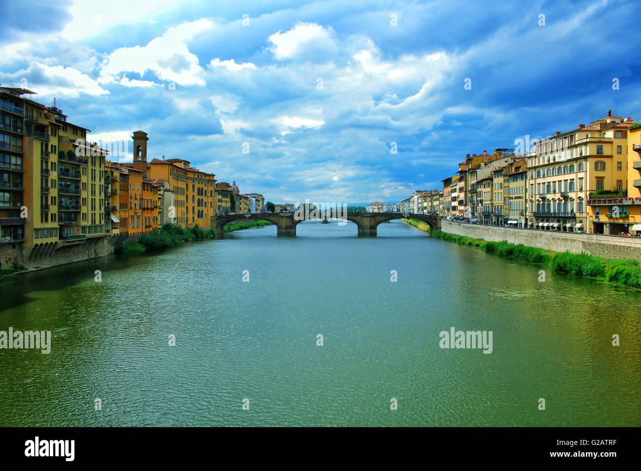 A lush river flowing through a Mediterranean city with a bridge Stock ...