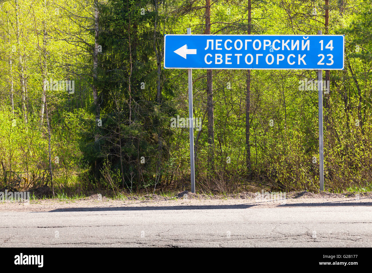 Blue road sign near highway with the names of settlements and the ...