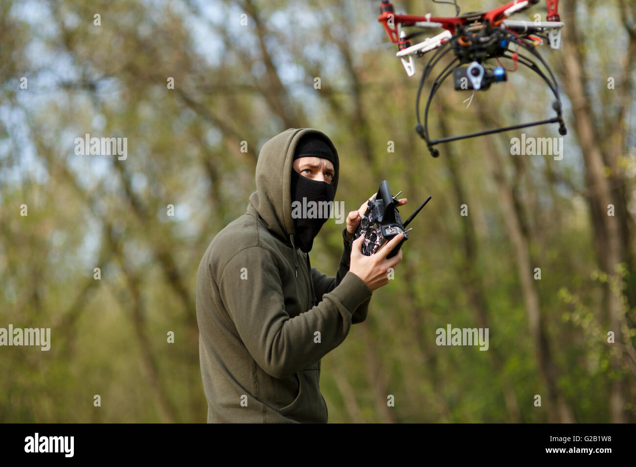 Man in mask operating a drone with remote control. Crime concept Stock ...