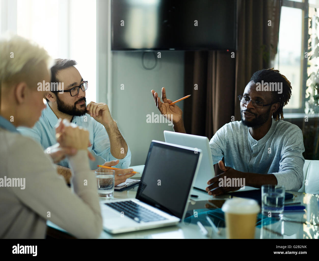 Discussion of young colleagues Stock Photo - Alamy