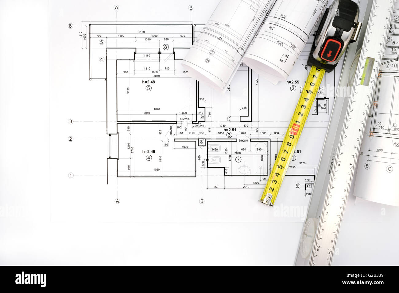 rolls of architectural blueprints and technical drawings with tape ...