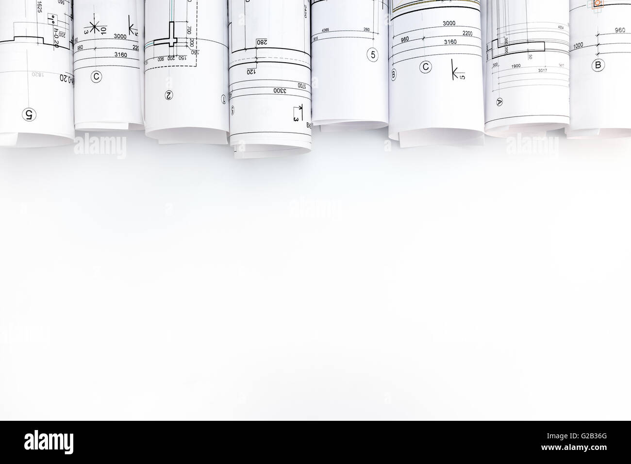 rolls of architecture blueprints and technical drawings on white ...