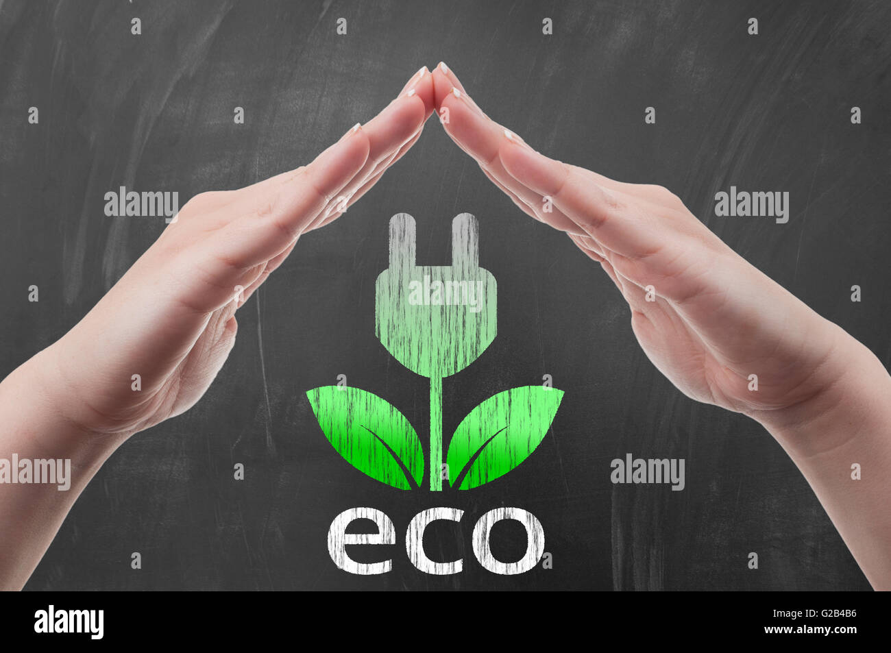 Hand protecting green energy concept draw on blackboard or school ...