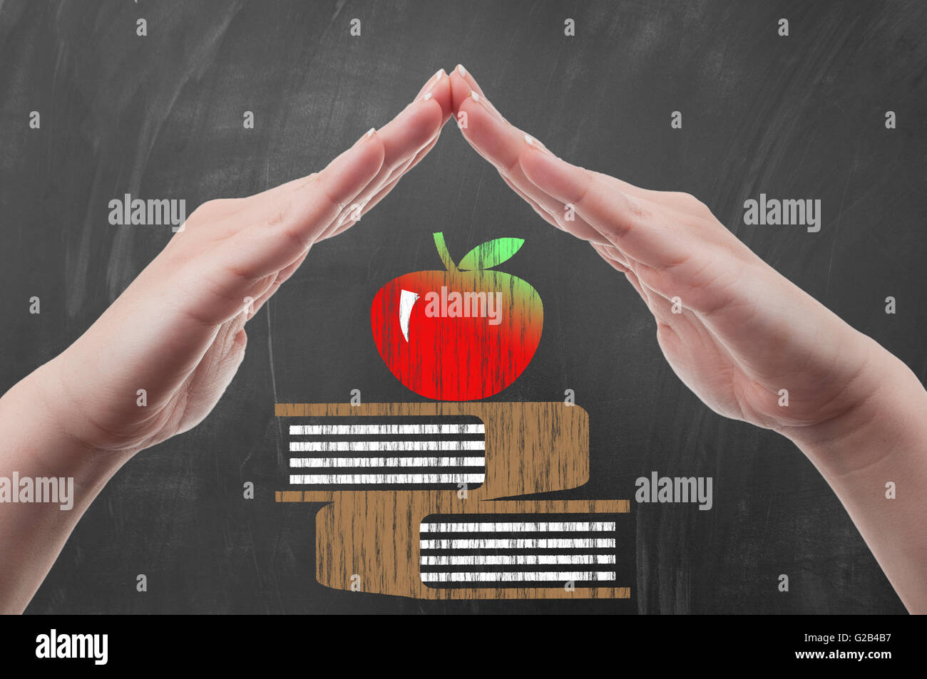Hand protecting books on school blackboard or chalkboard as education ...