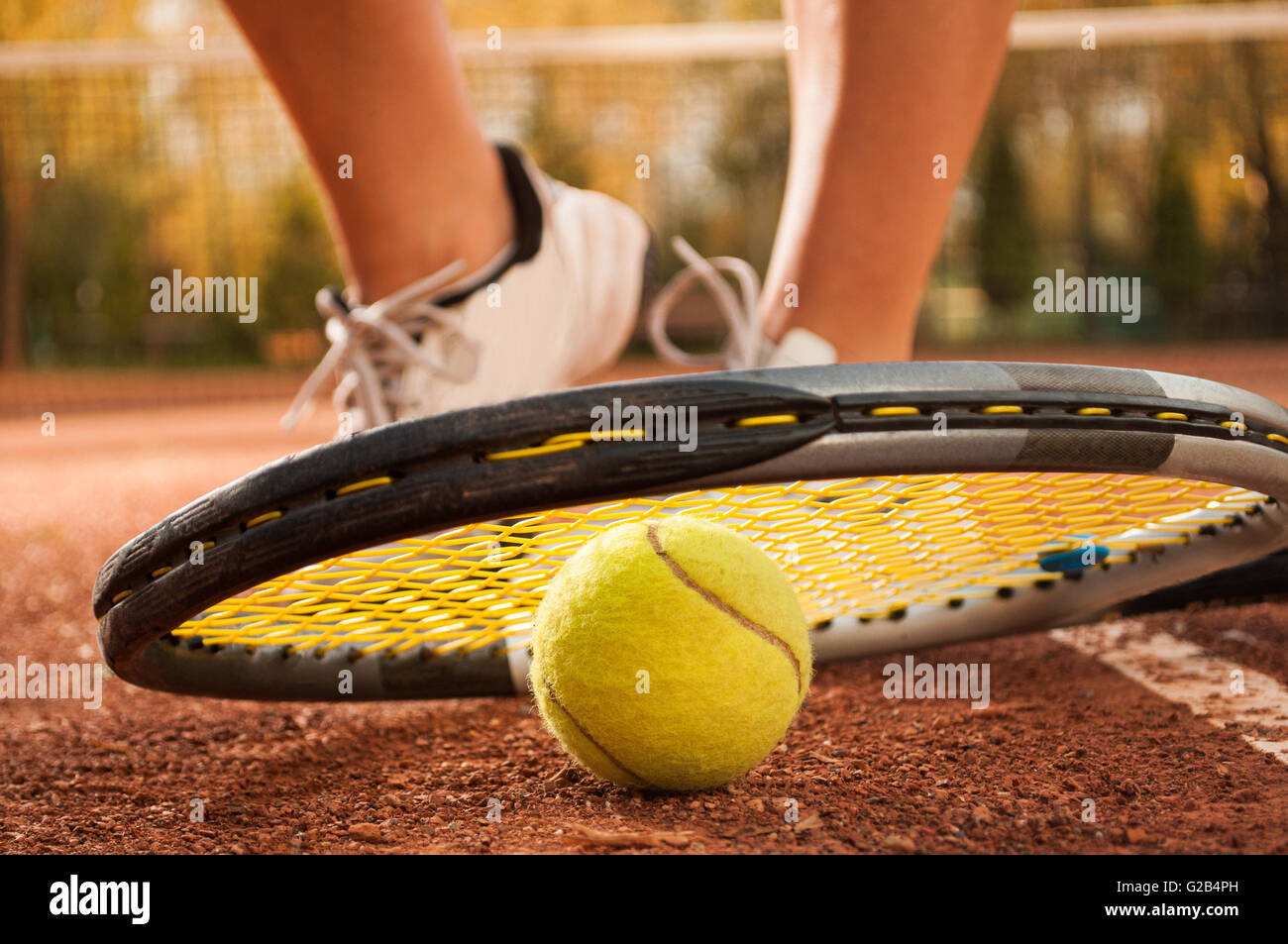 Tennis concept with ball, netting, racket and woman feet outdoor on ...