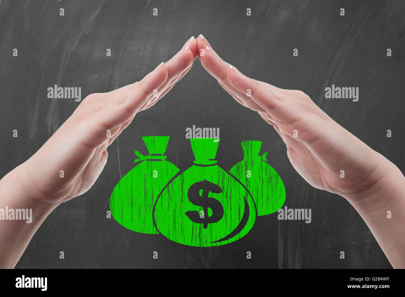 Hands protecting money bags draw on blackboard as savings protection ...