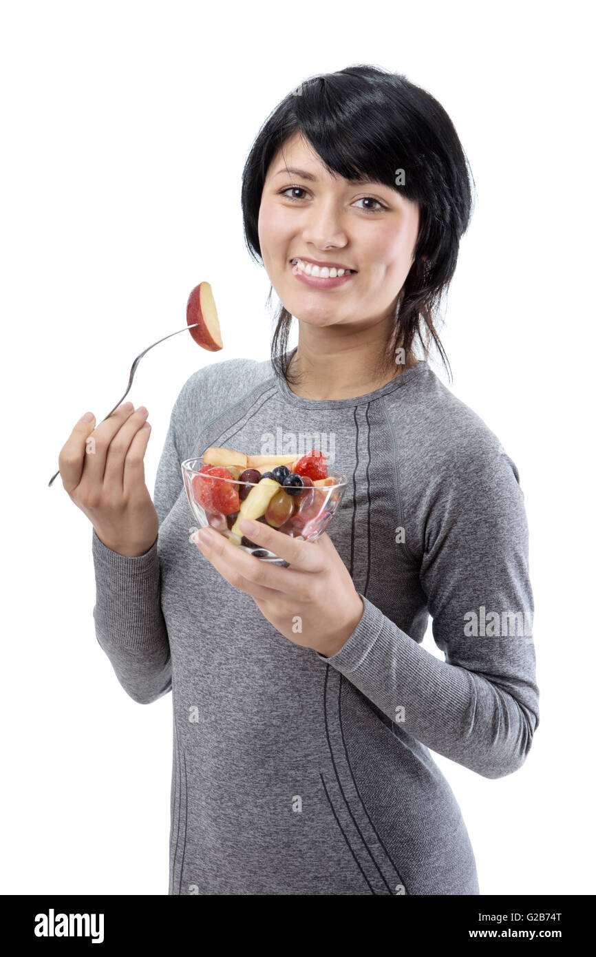 studio shot of a pretty, young, slim, fitness model eating a healthy ...