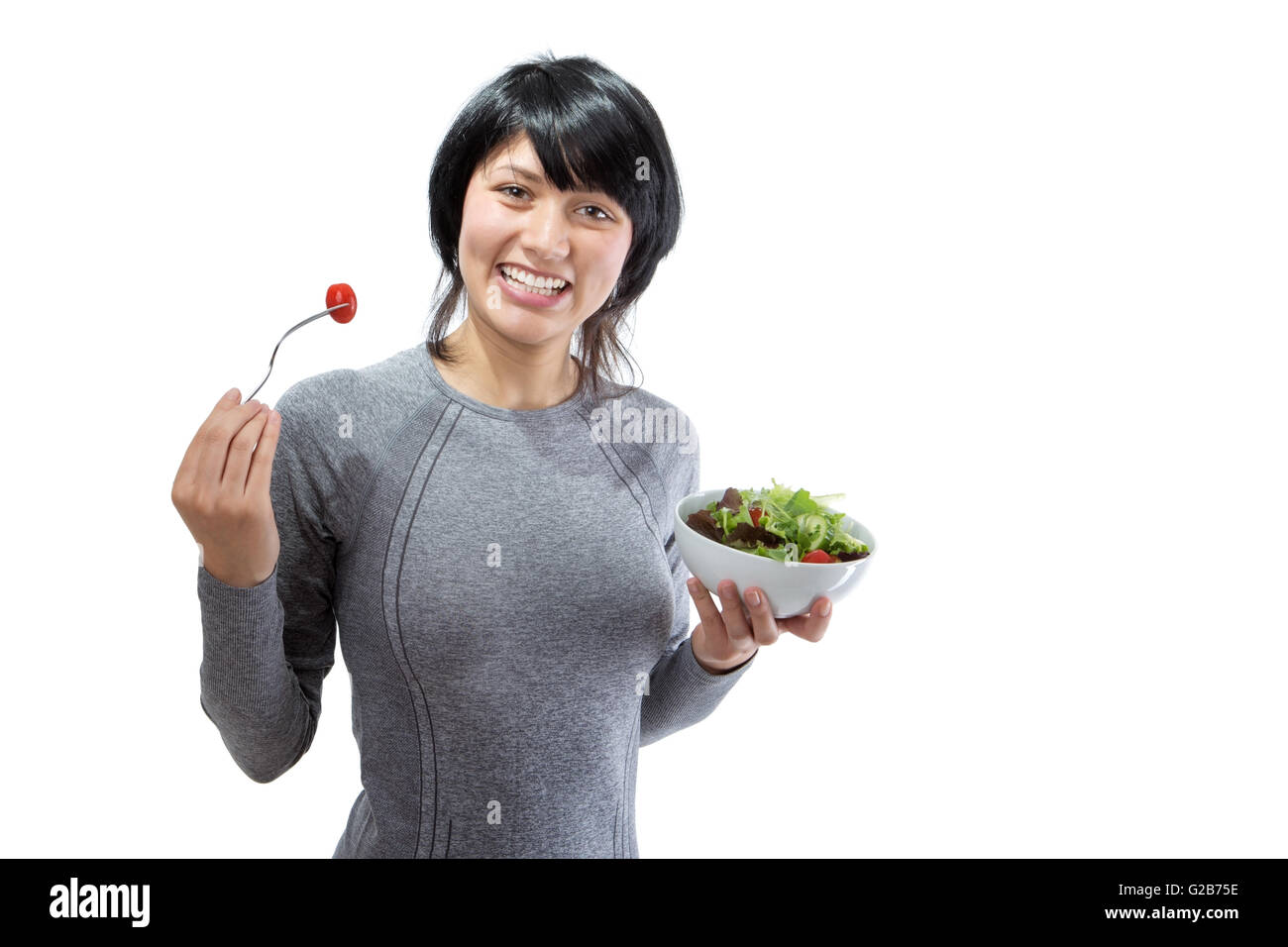shot of a pretty fitness model eating a healthy bowl of green salad ...
