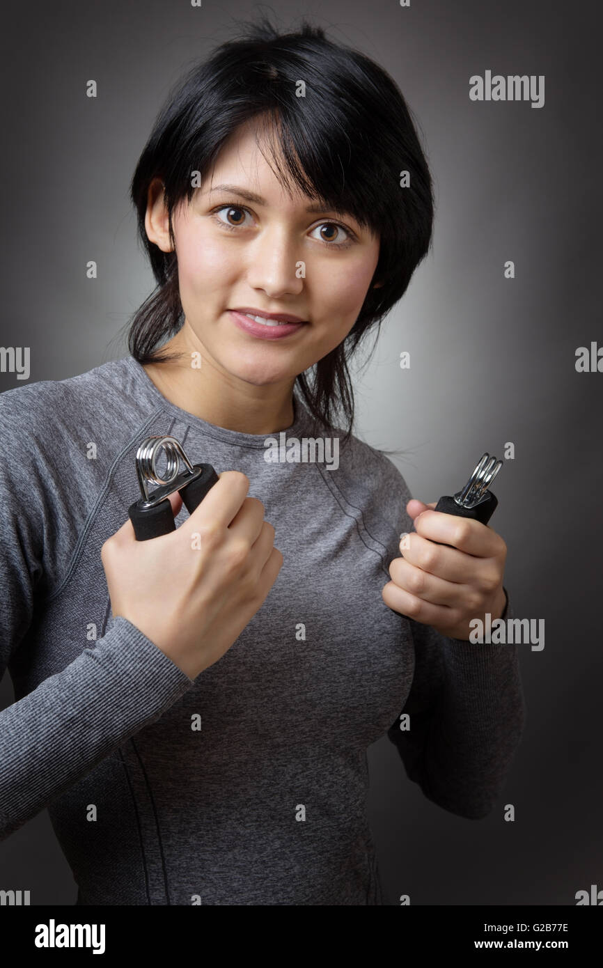 Fitness model doing hand grip exercise for strength. Low key lighting ...