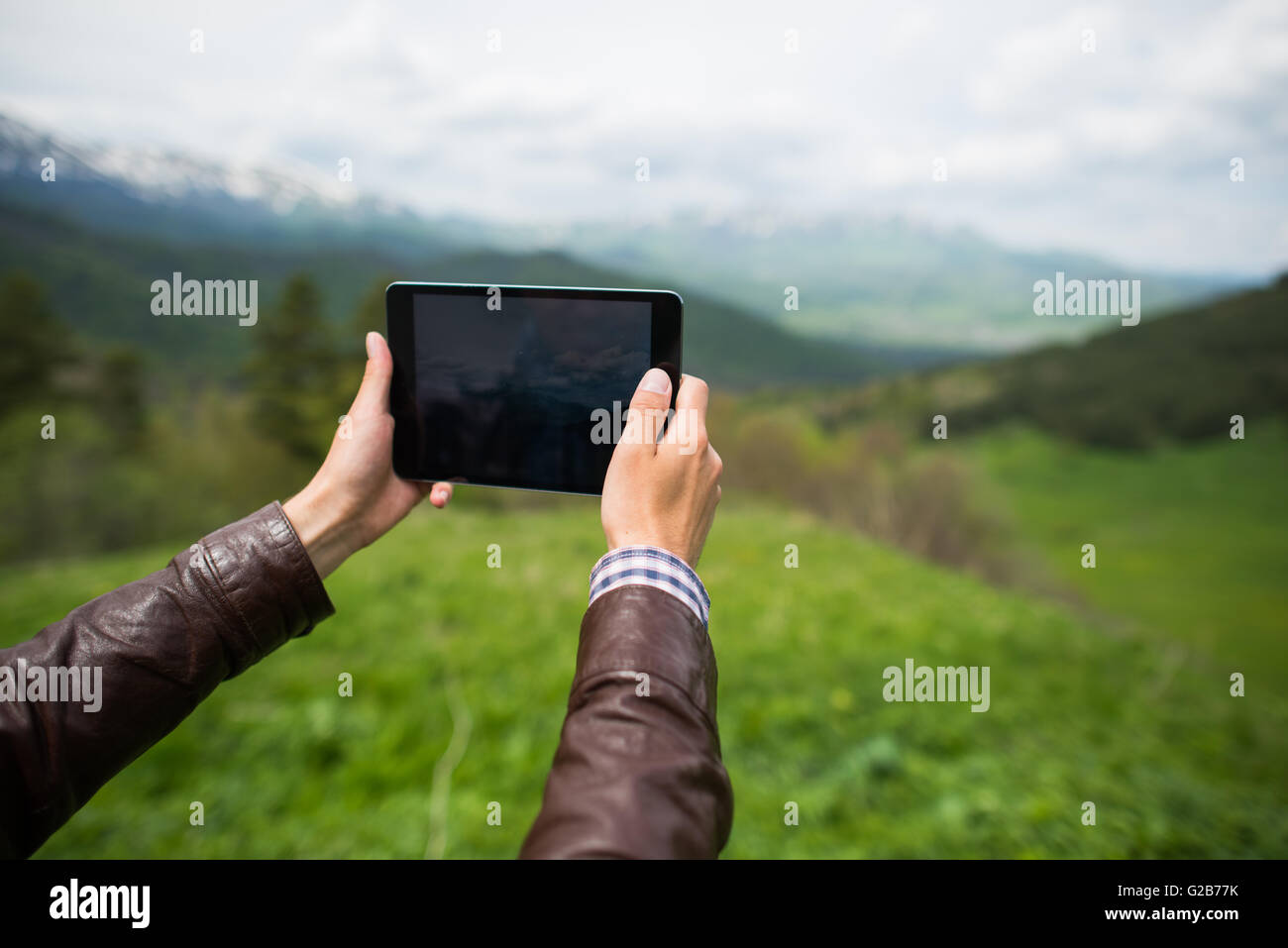Young man taking tablet selfie on mountain Stock Photo - Alamy