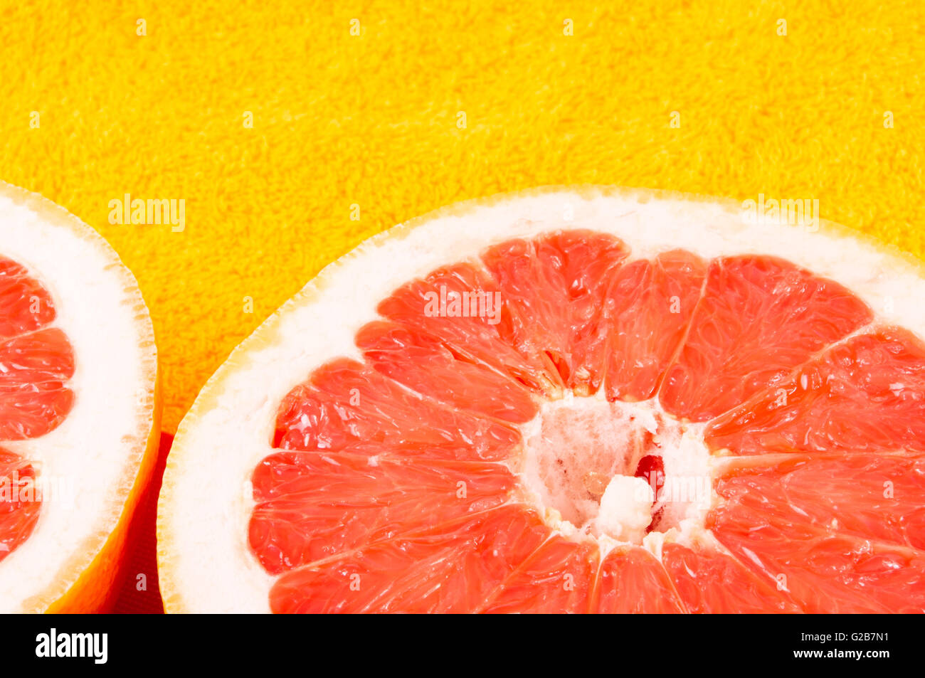 two halves of the grapefruit on yellow background Stock Photo - Alamy