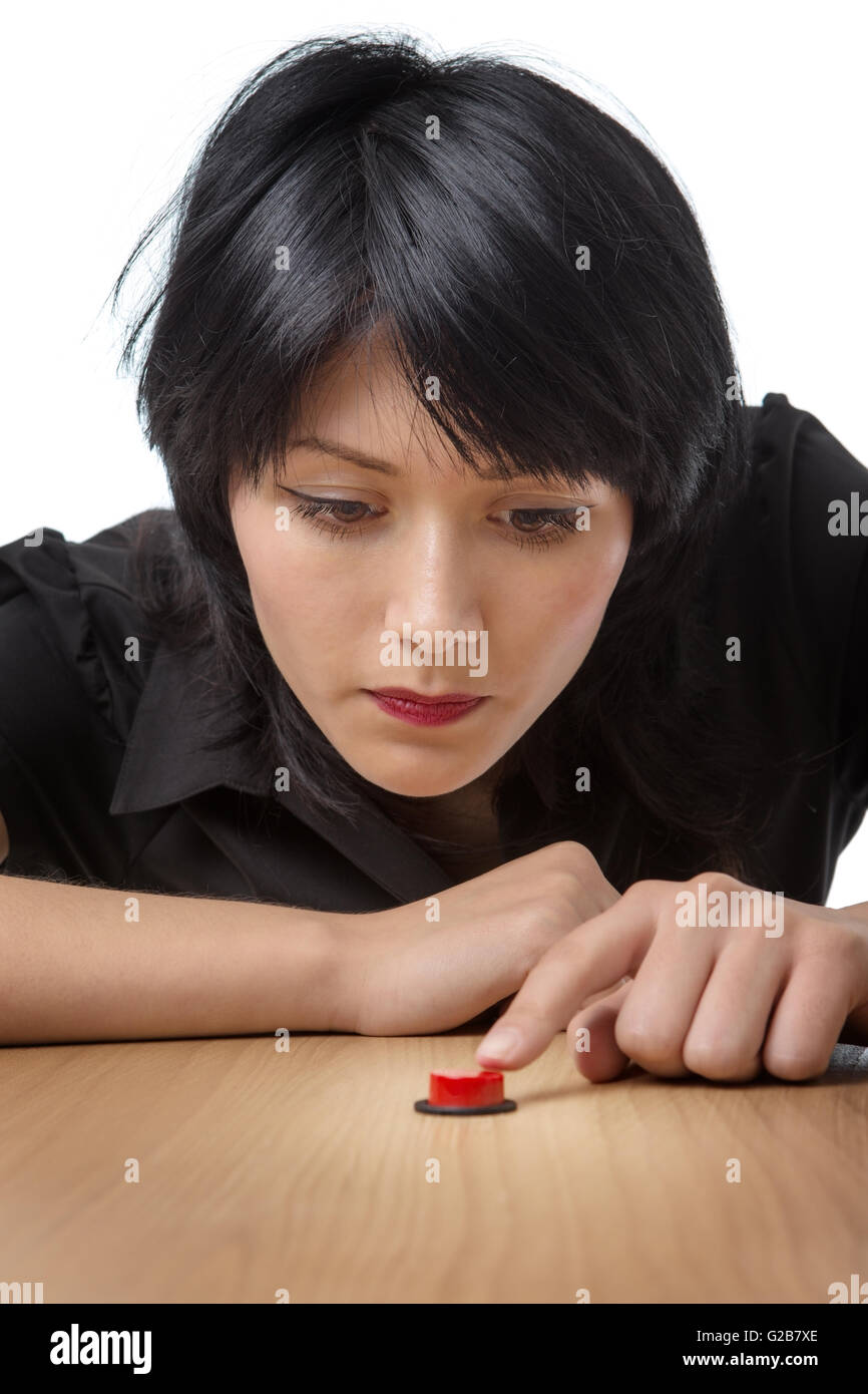 Studio shot of a thoughtful model holding her finger poised above a red ...