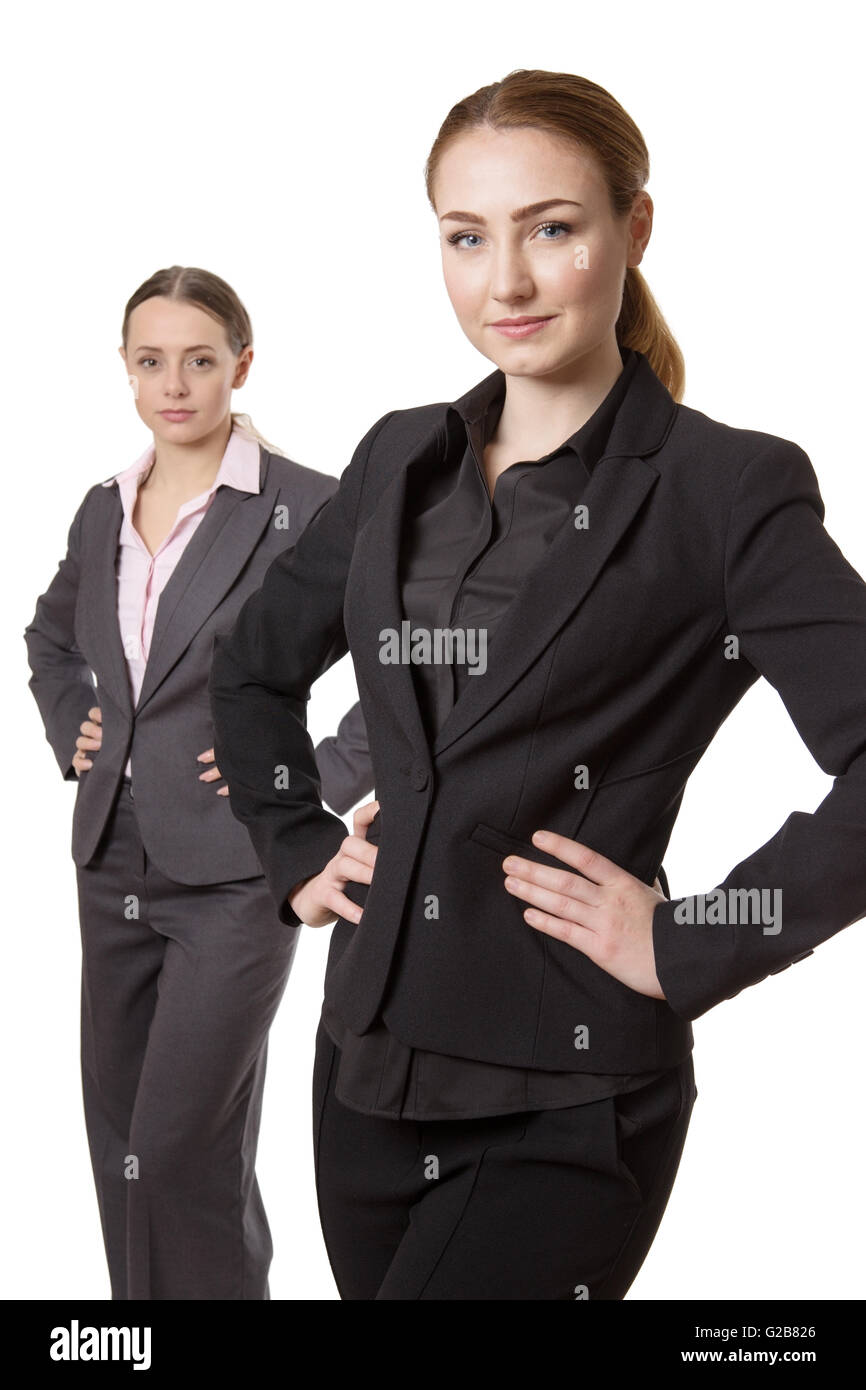 two happy, pretty business models wearing suits, looking serious and ...