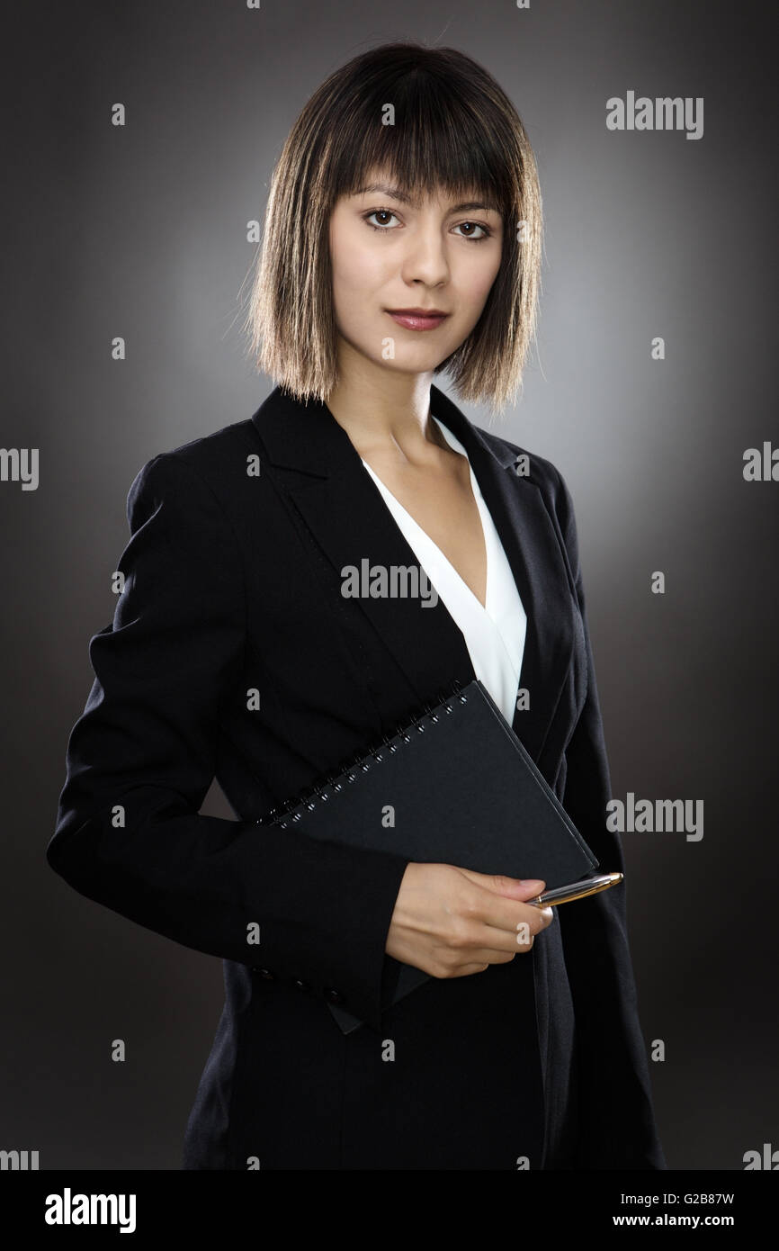 professional looking business woman holding a notebook and pen Stock ...