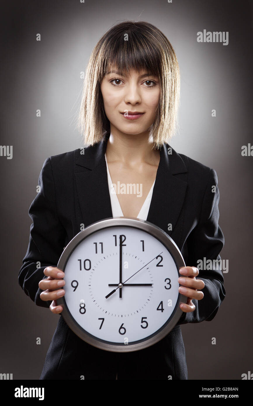 professional business woman holding a large clock Stock Photo - Alamy