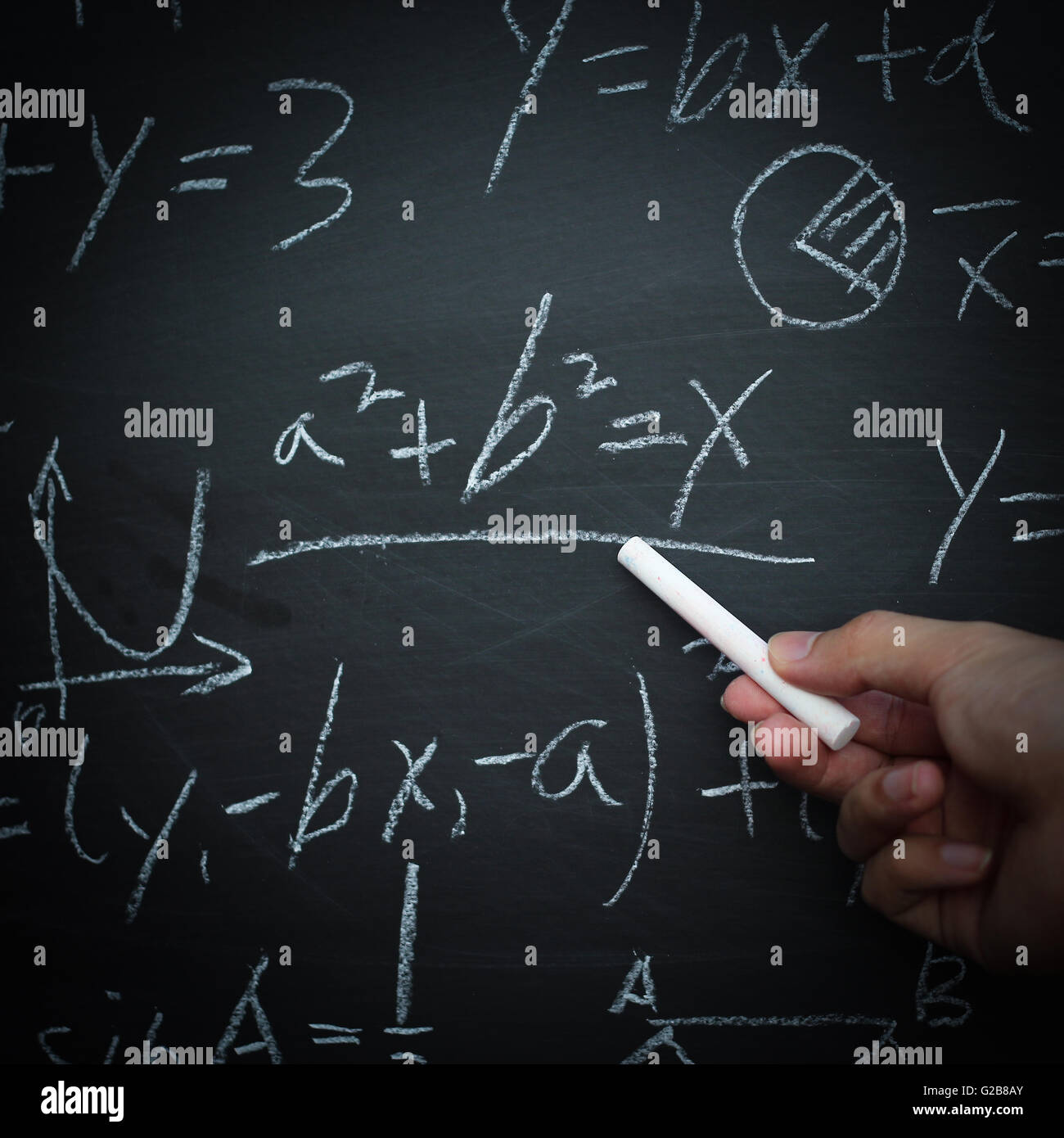 Teacher writing various high school maths formula on chalkboard Stock ...