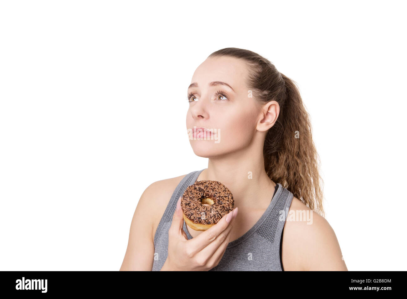 fitness woman eating a cheeky donut Stock Photo - Alamy