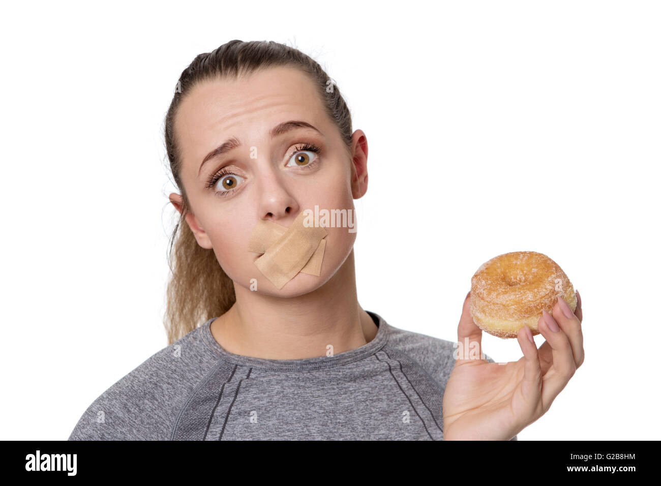 woman with first aid plaster over mouth unable to eat a dounut Stock ...
