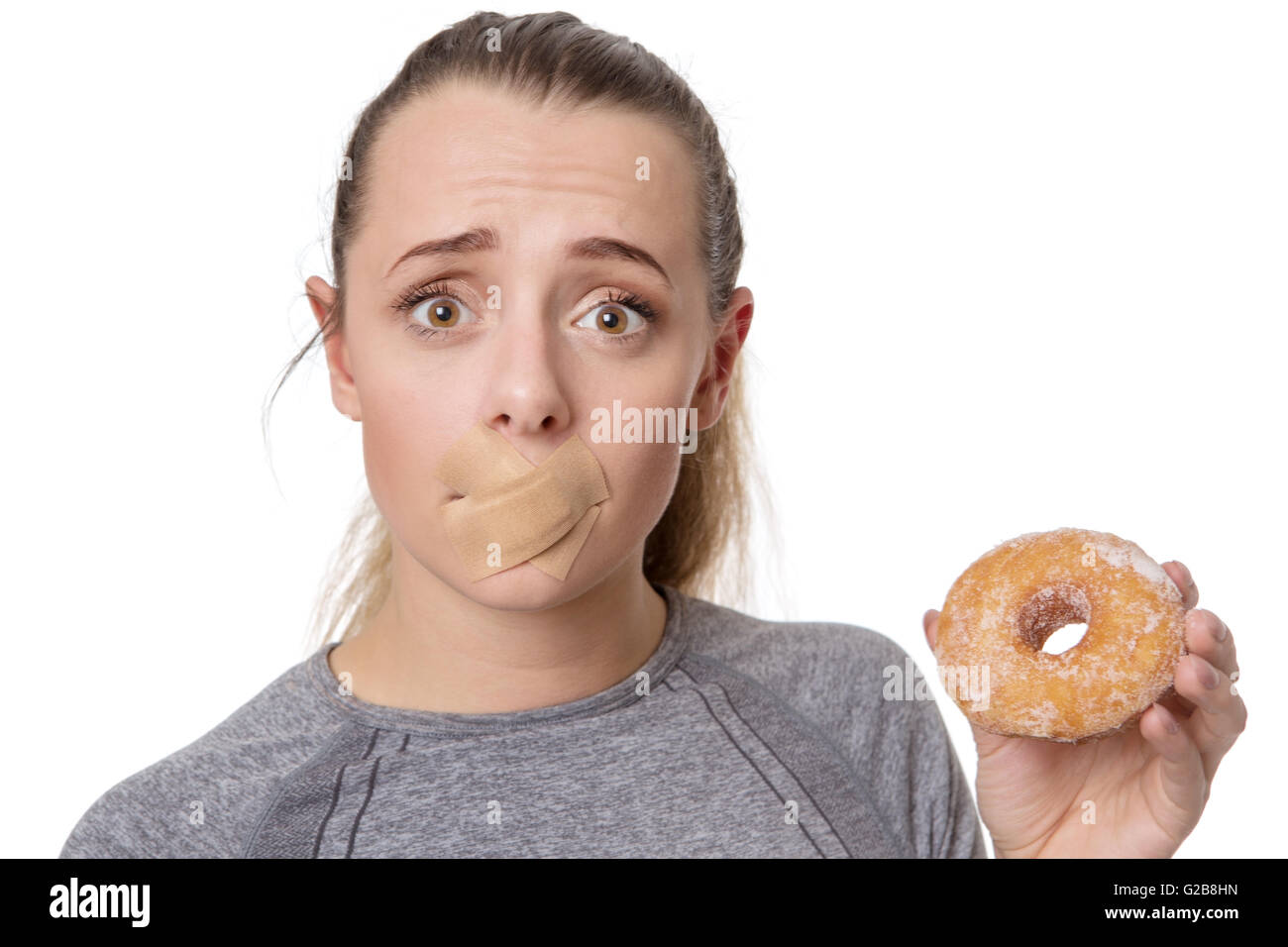 woman with first aid plaster over mouth unable to eat a dounut Stock ...