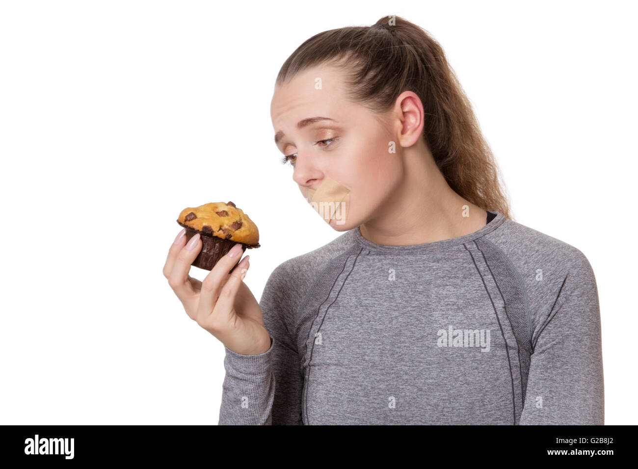 woman with first aid plaster over mouth unable to eat a muffin Stock ...