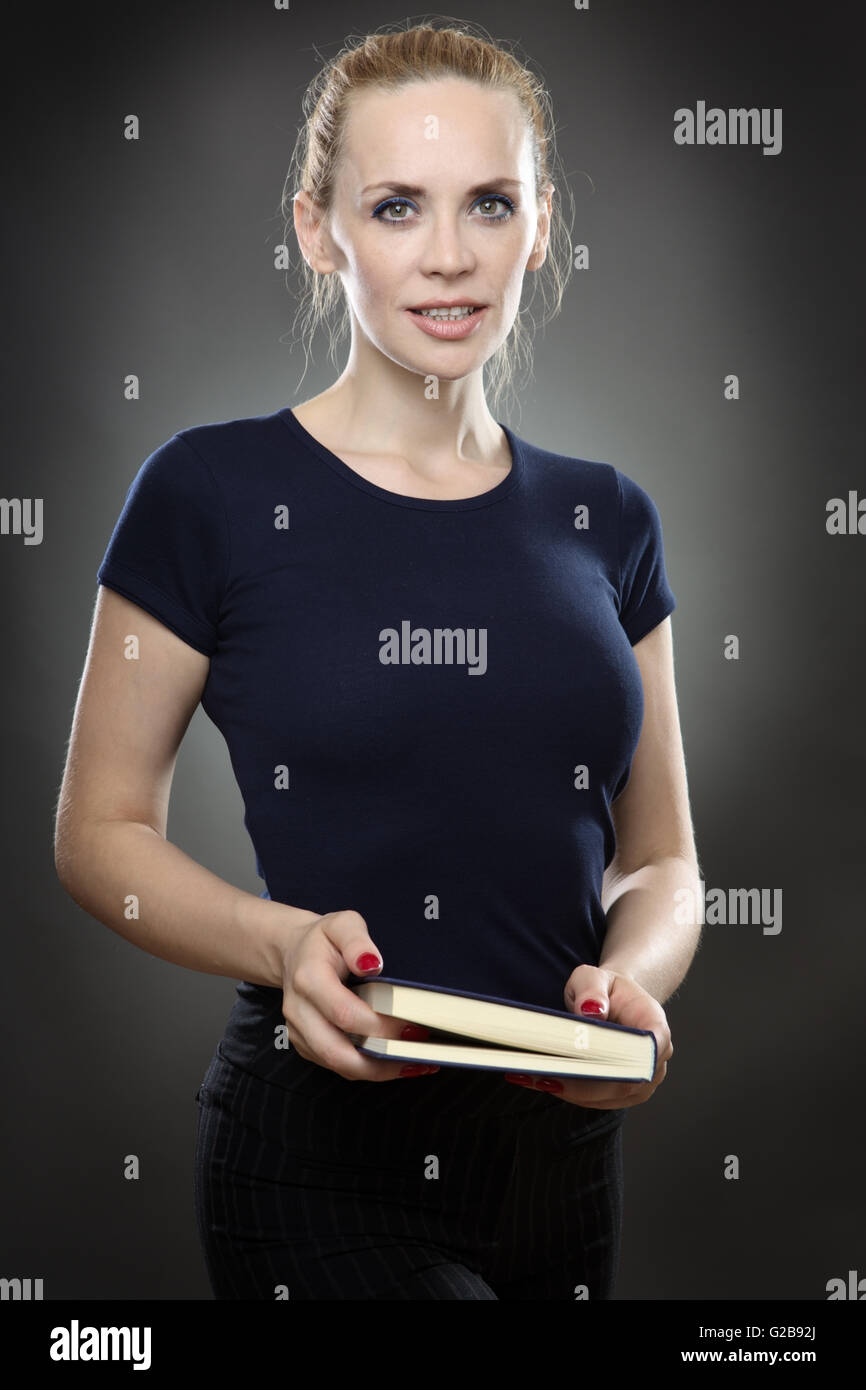 Upper body studio shot of a business woman holding a closed book. Shot ...