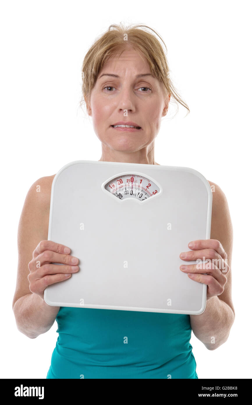 Fitness model is holding some scales infront of her, but looking ...