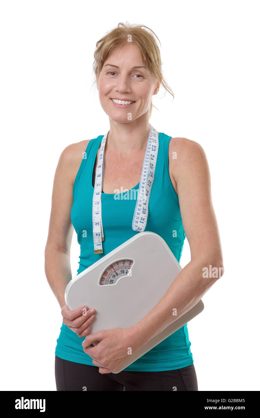 Healthy woman carrying measuring tape and a weight scale isolated over ...