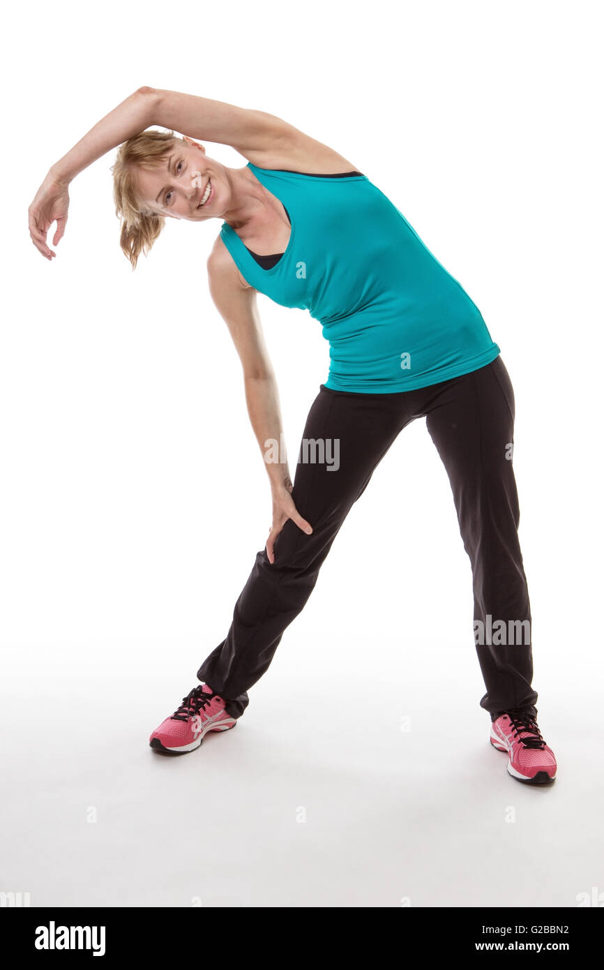 fitness model exercising, stretching the muscles of her arms and back ...