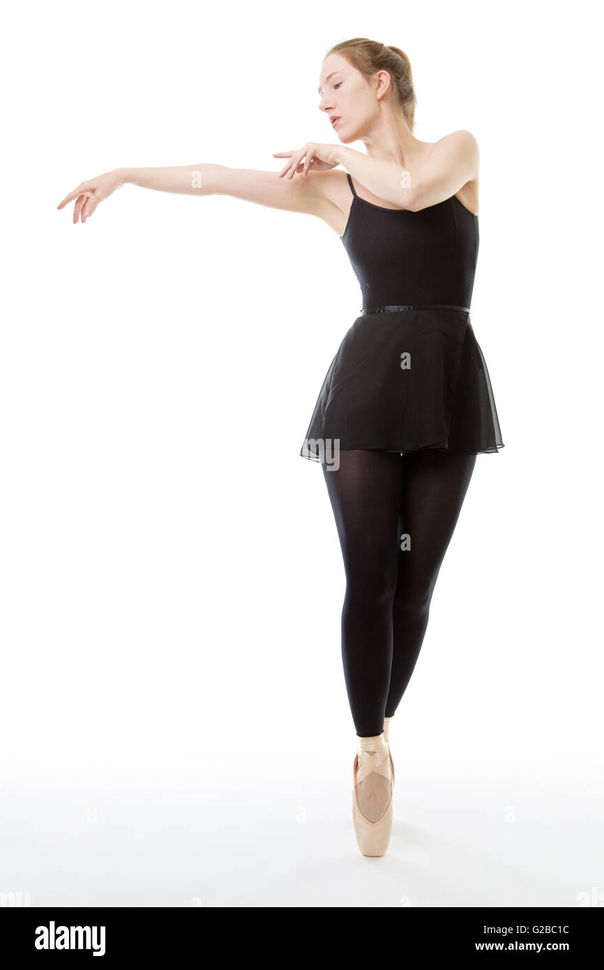 Full length studio shot of a beautiful ballerina, en pointe, dressed in ...