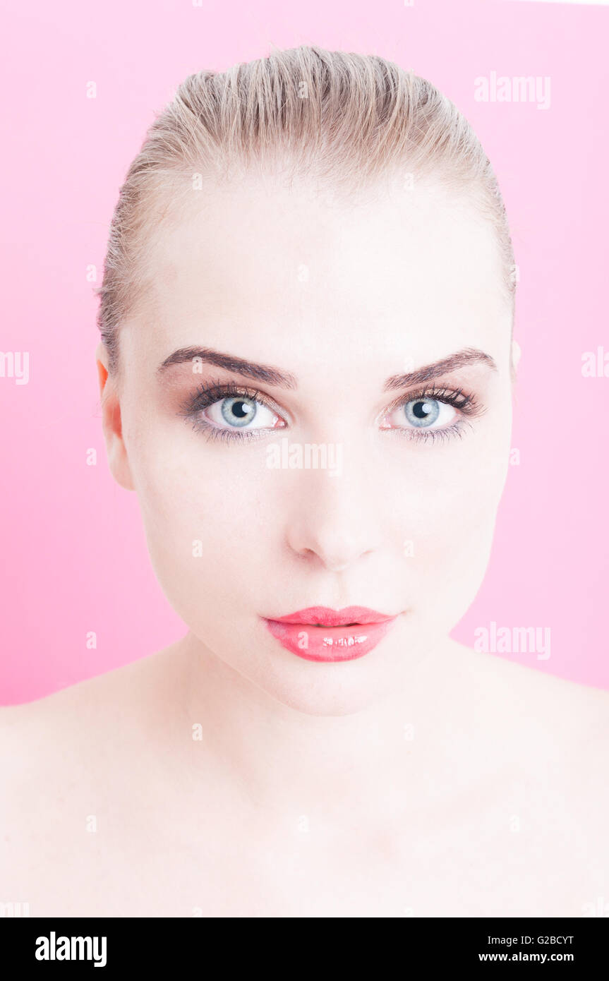 Portrait of beautiful face female model wearing daytime makeup isolated on pink background Stock ...