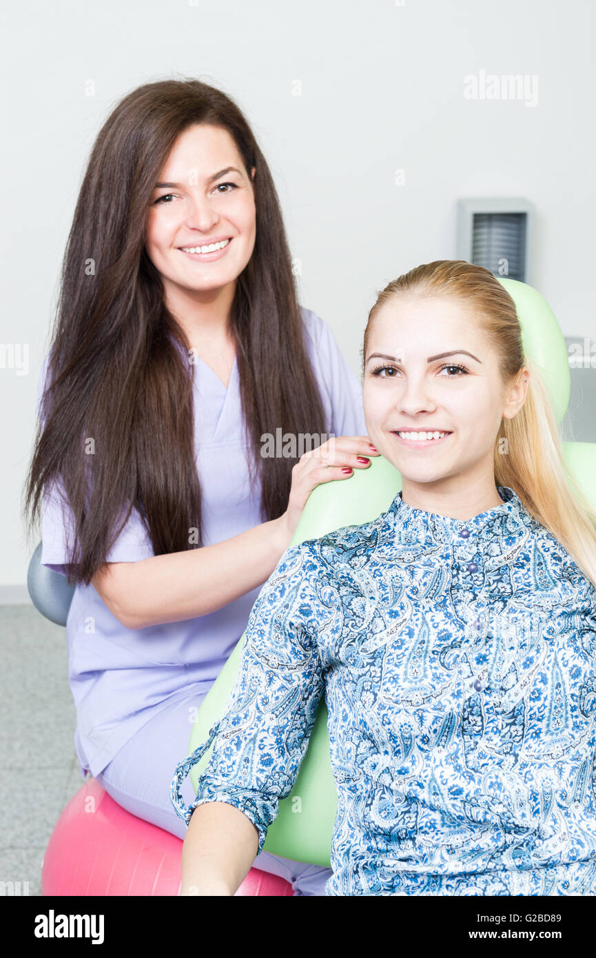 Beautiful dentist woman and cute female patient smiling in dental ...