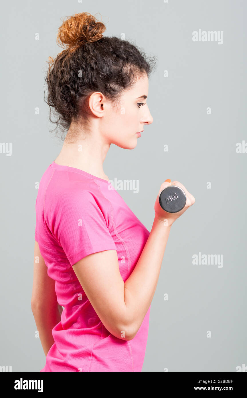 Profile of attractive woman holding dumbbell and exercising in fitness ...