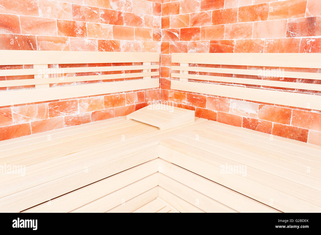 Wooden bench, salt wall and headrest support in sauna room as ...