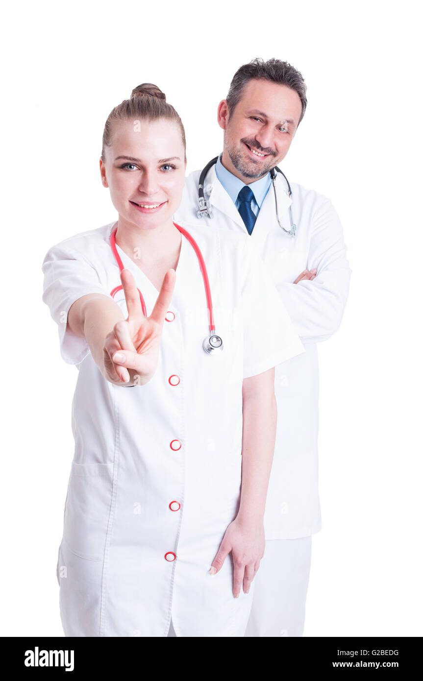 Happy doctors smiling friendly and showing peace or victory gesture on ...