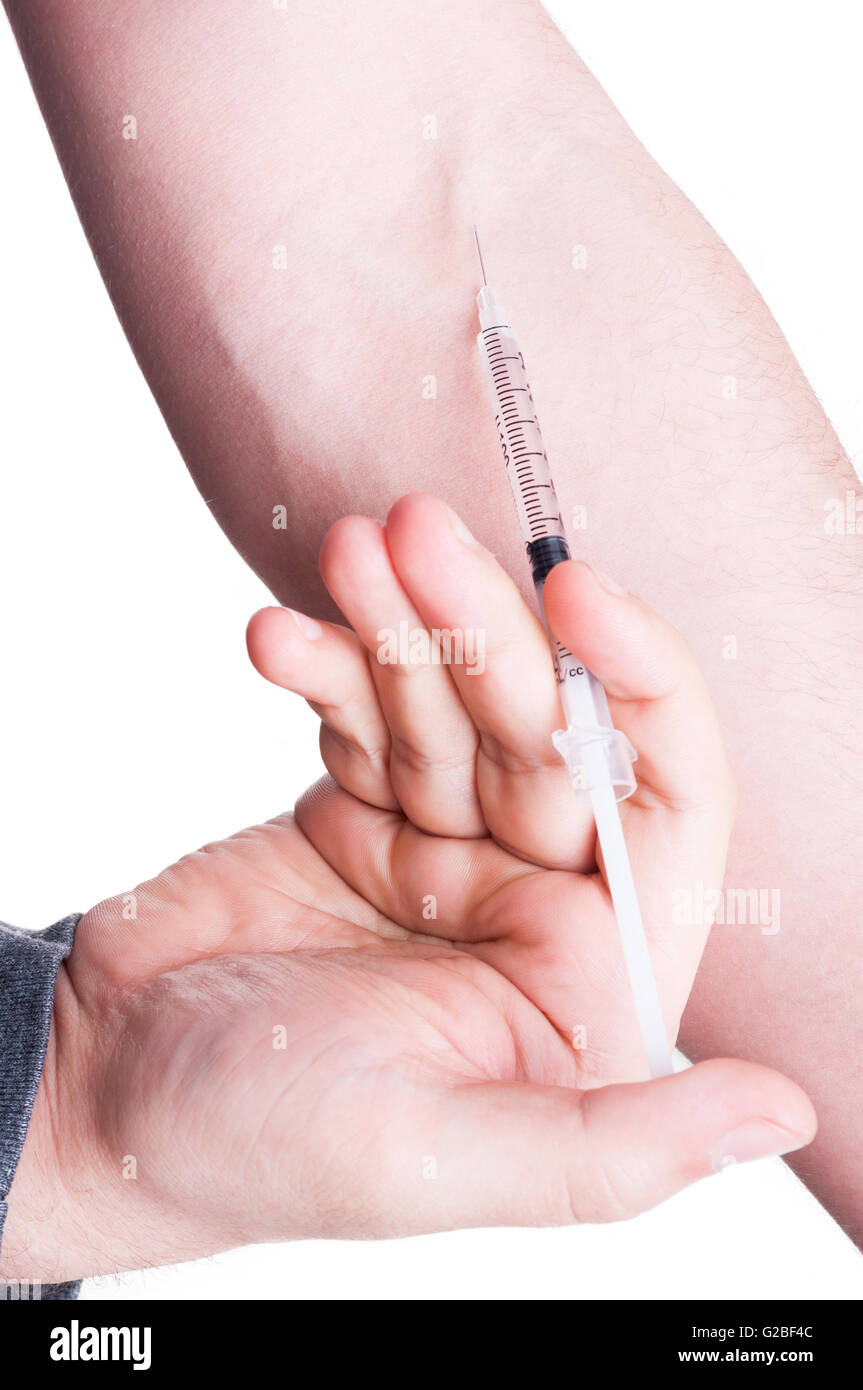 Close-up of man doing an injection in his vein as imunity treatment or ...