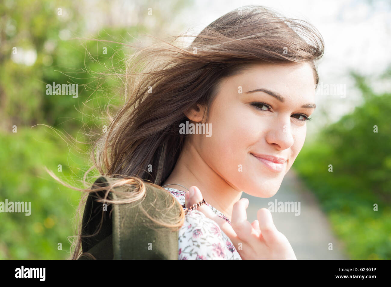 Closeup portrait of beautiful woman walking by herself in natural park ...