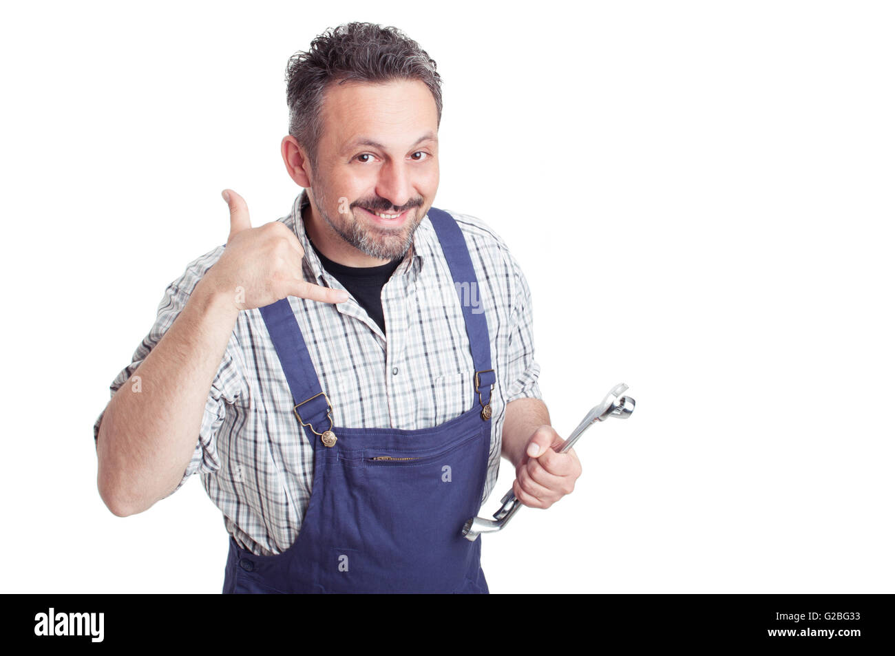 Friendly man holding wrench and making a call me sign with his hand ...