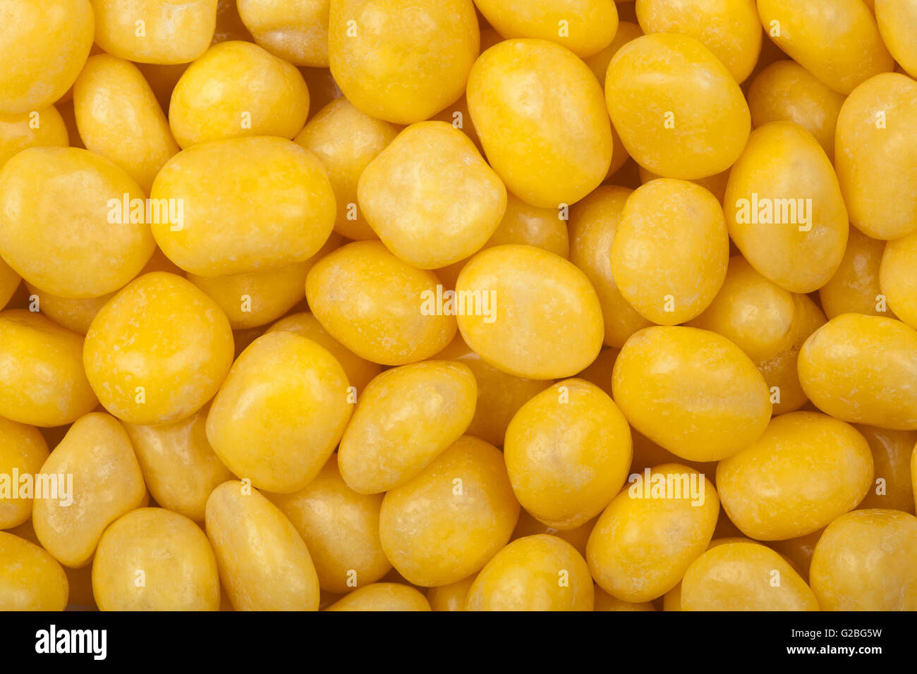 Yellow sweets, sugar covered nuts, background Stock Photo - Alamy
