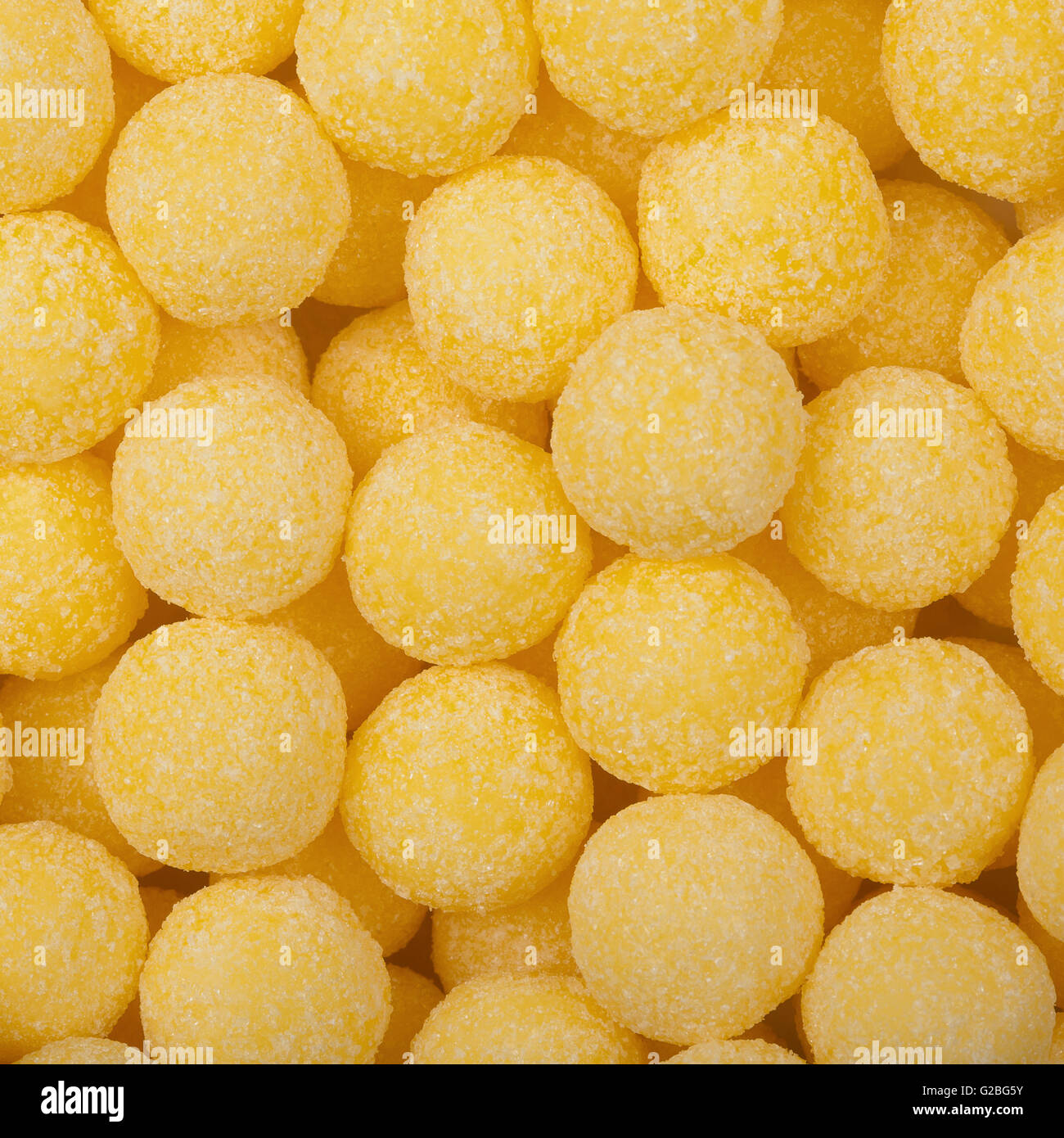 Yellow sweets, sugar covered nuts, background Stock Photo - Alamy
