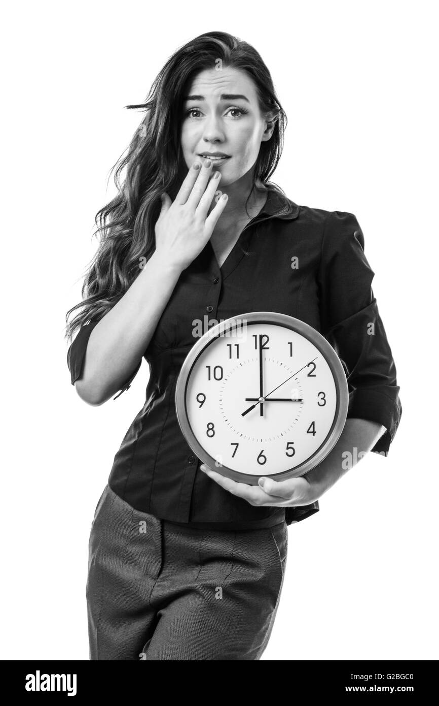 Woman in a suit holding a large clock looking a little bit worried ...