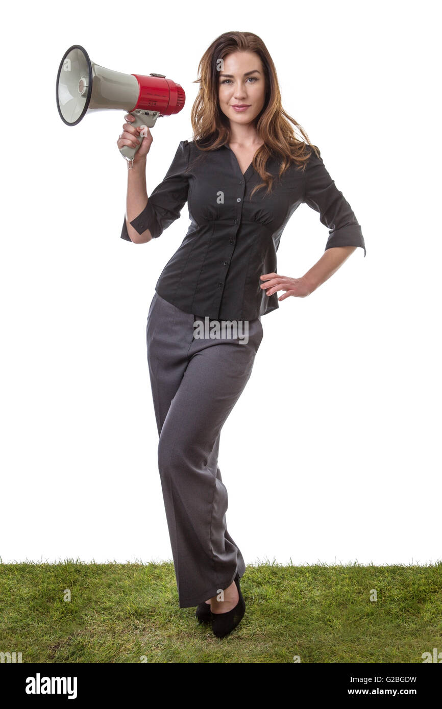 Pretty brunette holding a loud speaker in a business suit, standing on ...
