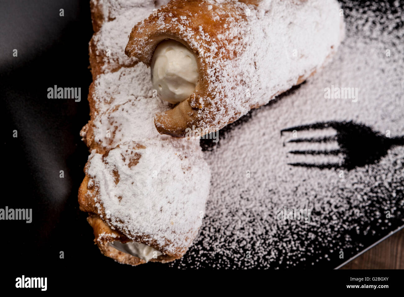 Sweets with sugar on black plate with a fork mark Stock Photo - Alamy