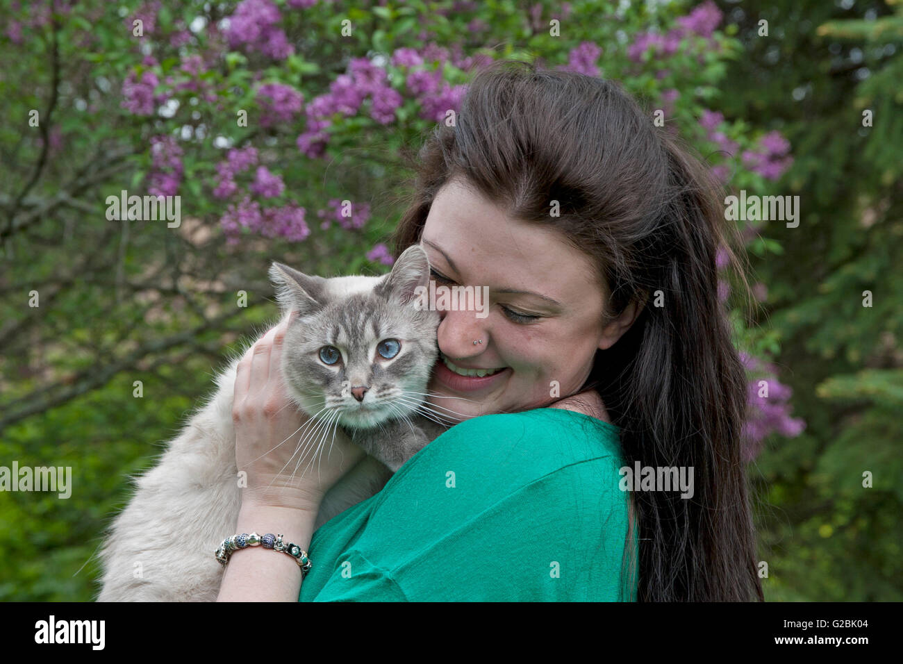 Woman cuddles Siamese mix cat in springtime Stock Photo - Alamy