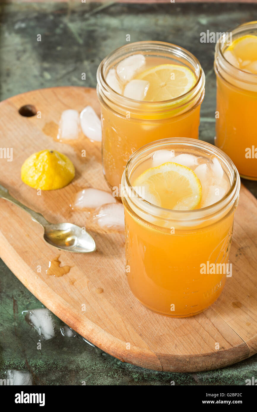 Glass jars filled with homemade Switchel on wooden cutting board and ...