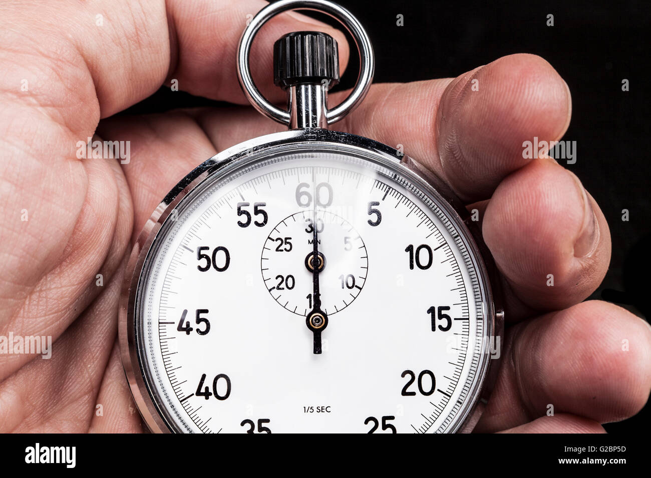Chronometer in hand isolated on black background Stock Photo - Alamy